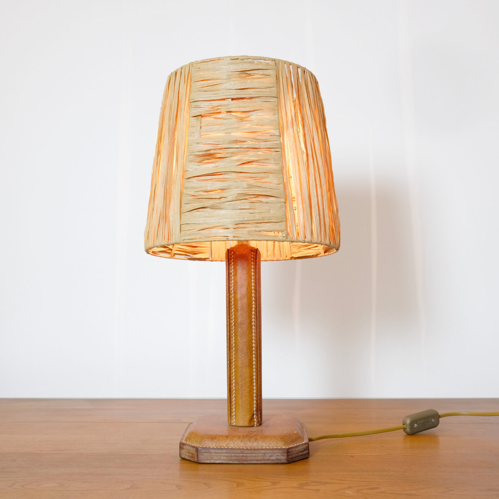 Leather table lamp and its raffia shade. — LampAndCo